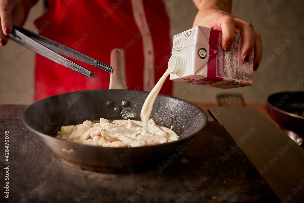 hand pouring milk cream into a frying pan with shrimp paste Stock Photo ...