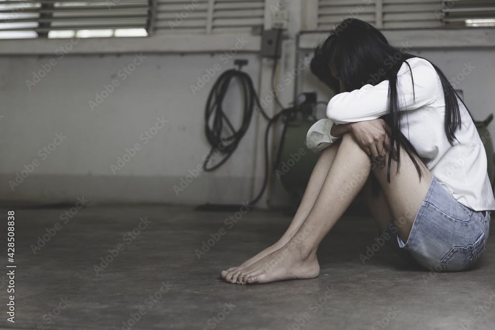 Young depressed woman, domestic and rape violence,beaten and raped sitting in the corner ...