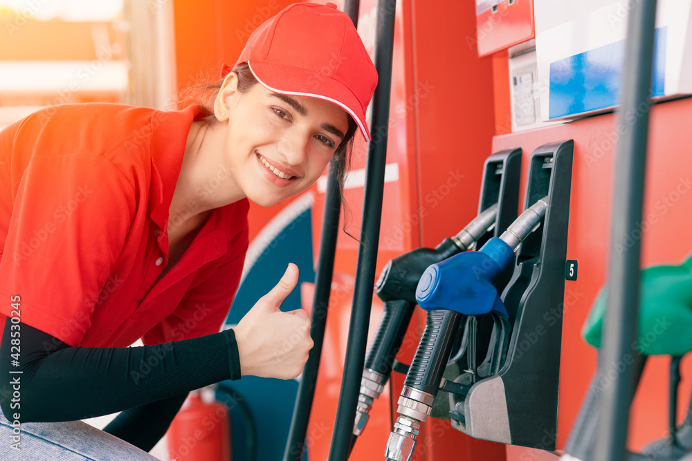 Gas station women worker staff Thumbs up at fuel nozzle dispensers ...