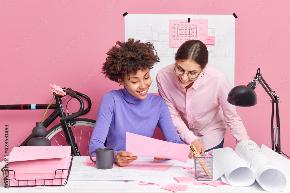 Creative cooperation and teamwork concept. Two cheerful mixed race ...