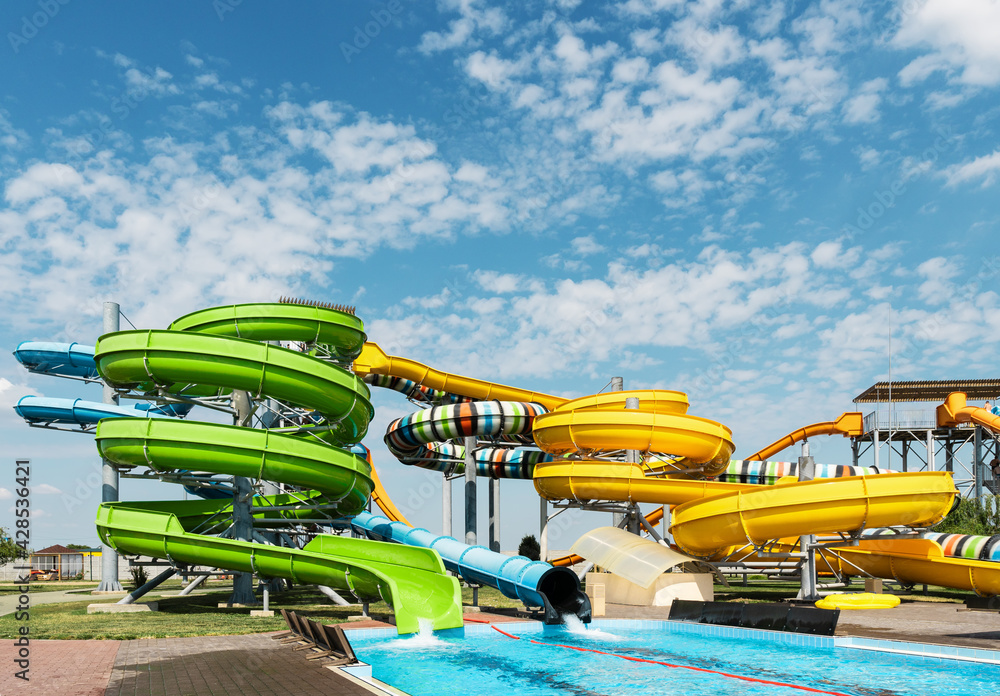 water park, bright multi-colored slides with a pool, a water park on a ...