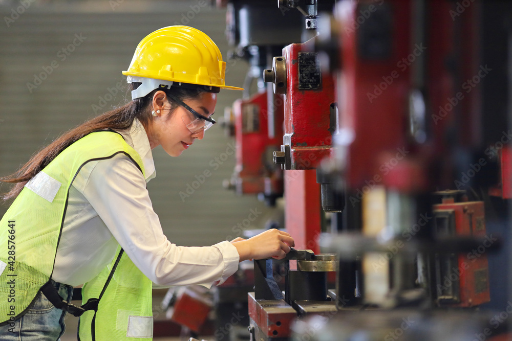 Asian female mechanic worker in safety hard hat and reflective cloth is ...