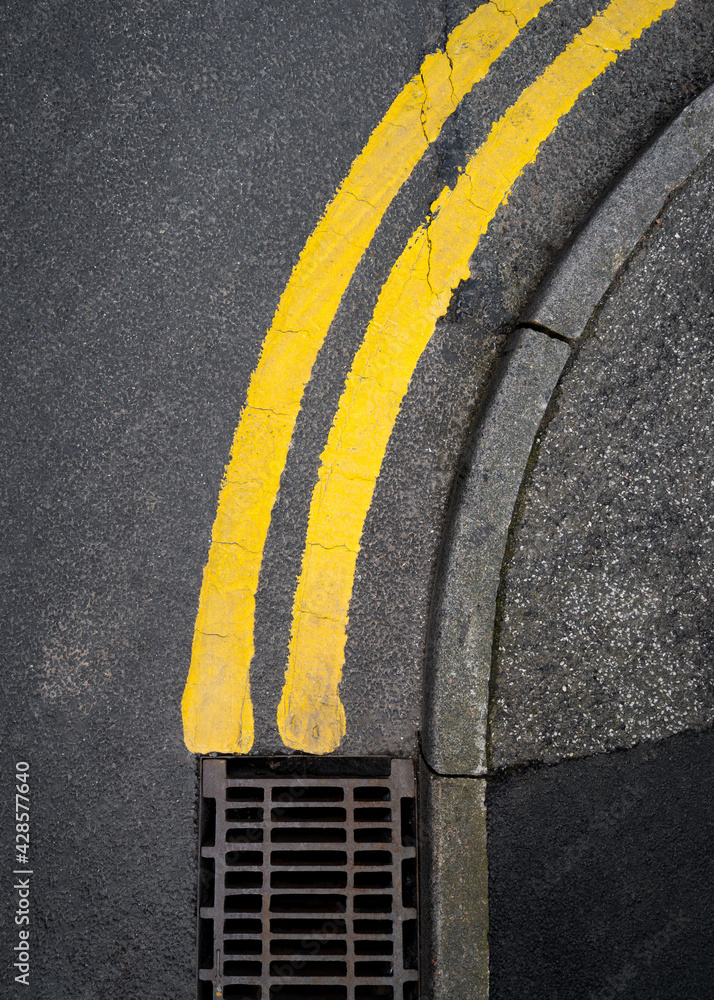 No parking two bright double yellow lines restriction painted on black ...