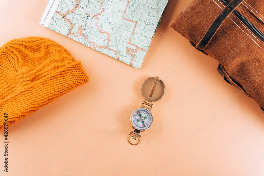 Travel concept, on the table is a yellow hat, compass ,green map of the ...