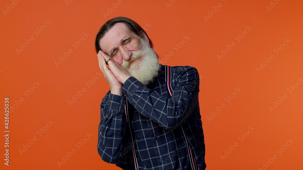 Tired elderly bearded gray-haired man going to sleep laying down on his ...