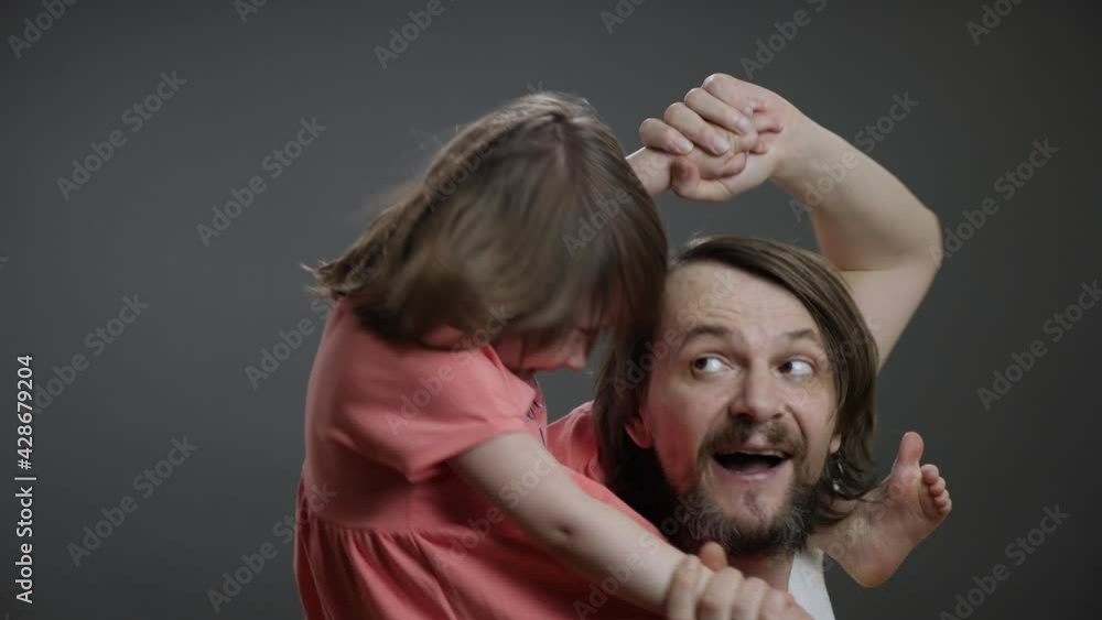 Piggyback ride on daddy. Young father throws his daughter hanging on ...