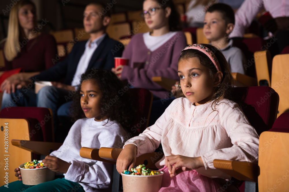Preteen girl with her mulatta mate sitting in comfortable chairs in ...