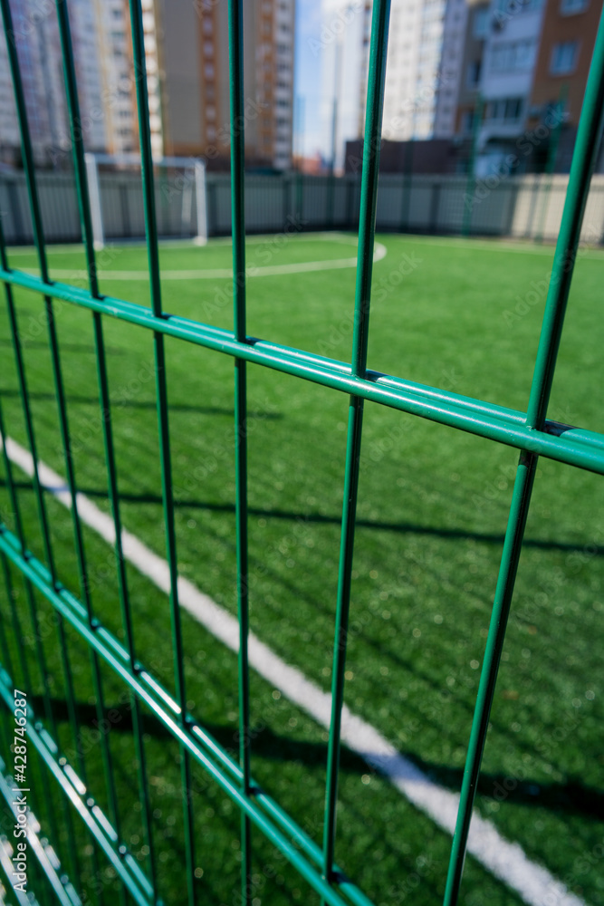 Lawn field for playing football behind the green fence mesh Stock Photo ...