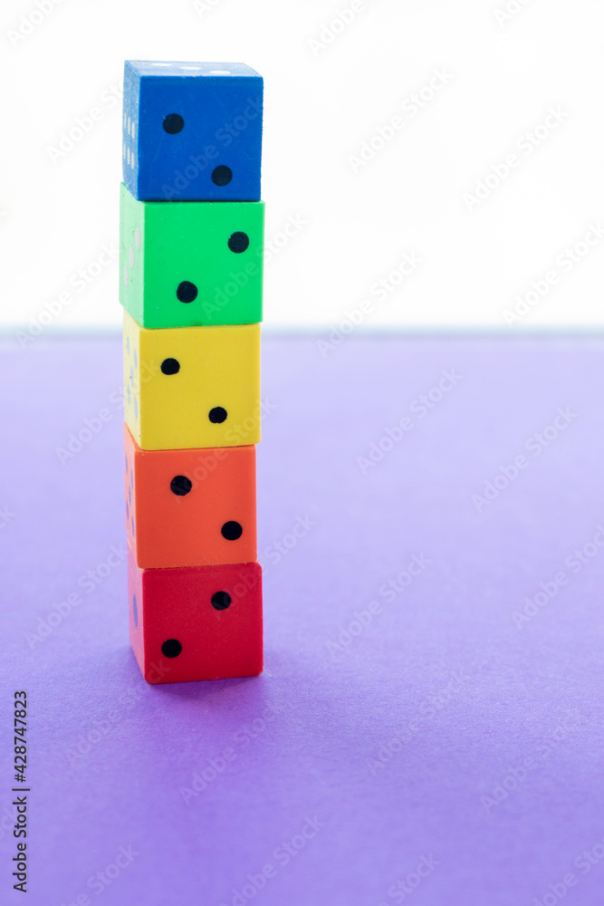 Five colored blocks one on top of the other forming a tower, all on a ...