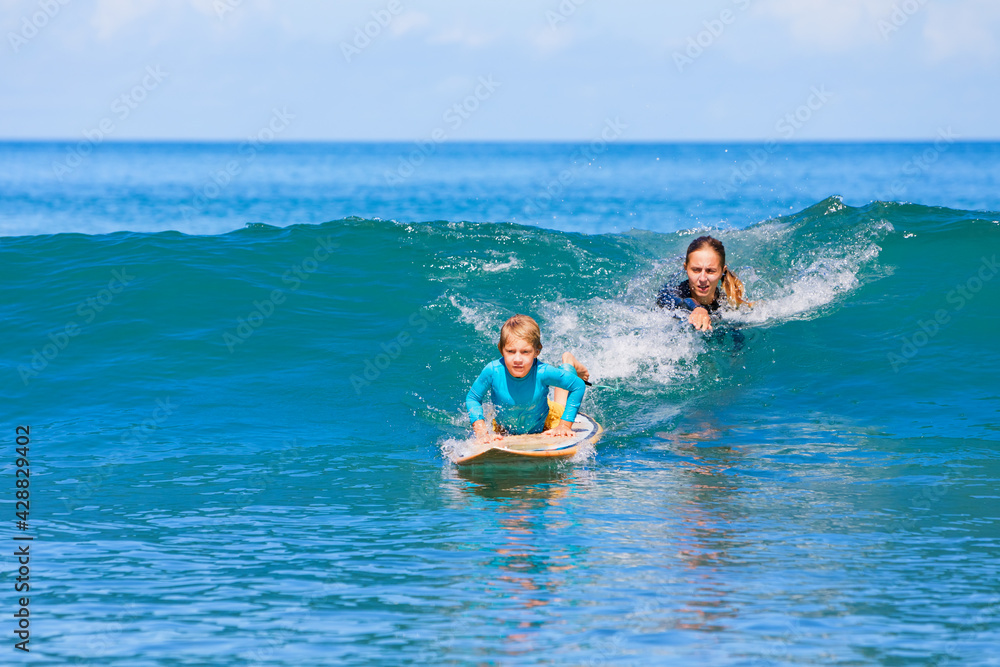 Little surf boy - young surfer learn to ride on surfboard with ...