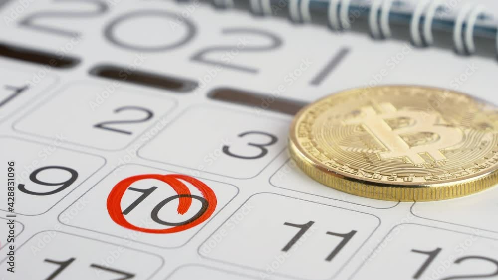 Bitcoin and red circle mark on a calendar date. Hand marks the day on ...