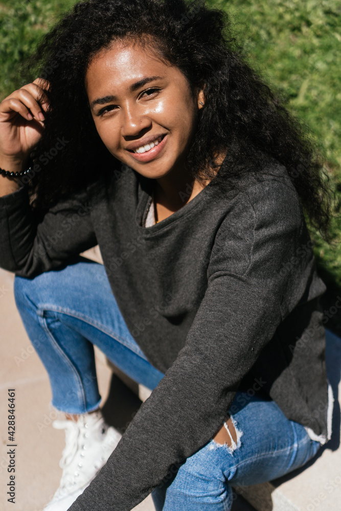 portrait of an afro girl sitting in the open air Stock Photo | Adobe Stock