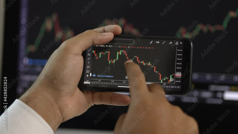 Businessman using smartphone looking Stock market. Stock chart goes up ...