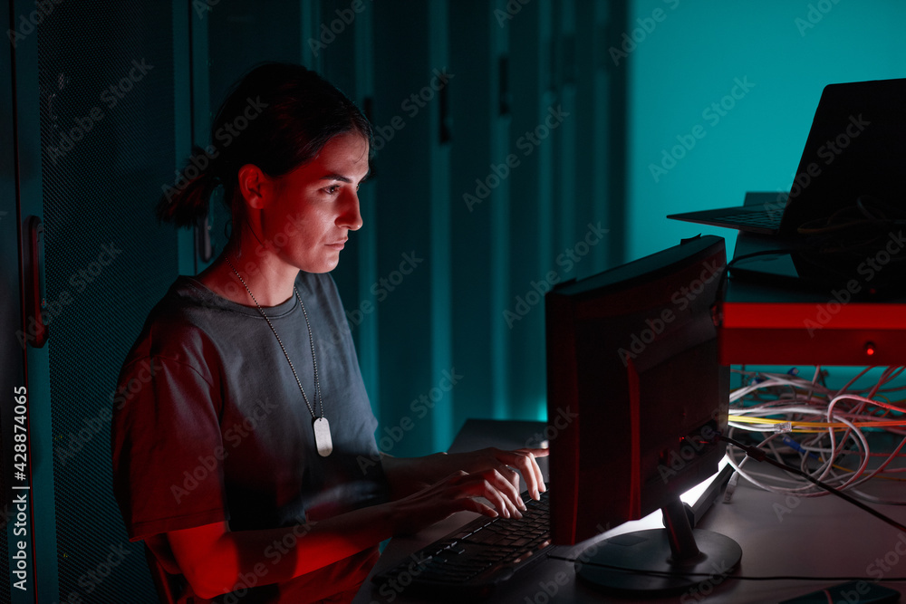 Side view portrait of female IT engineer using computer while working ...