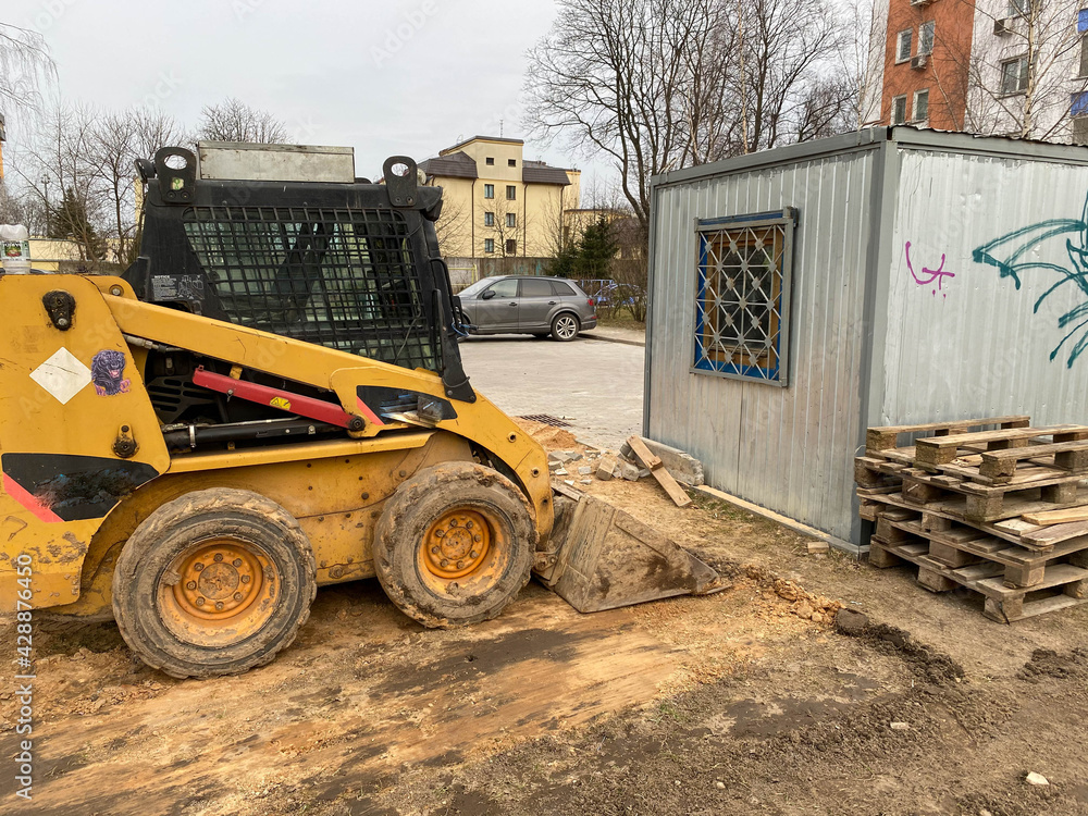 Small but powerful yellow construction excavator with a bucket. Modern ...