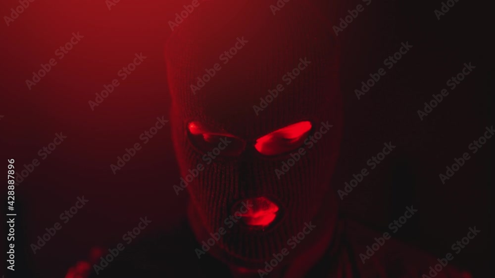 Portrait of an arrested criminal in a mask. Thief with balaclava with ...