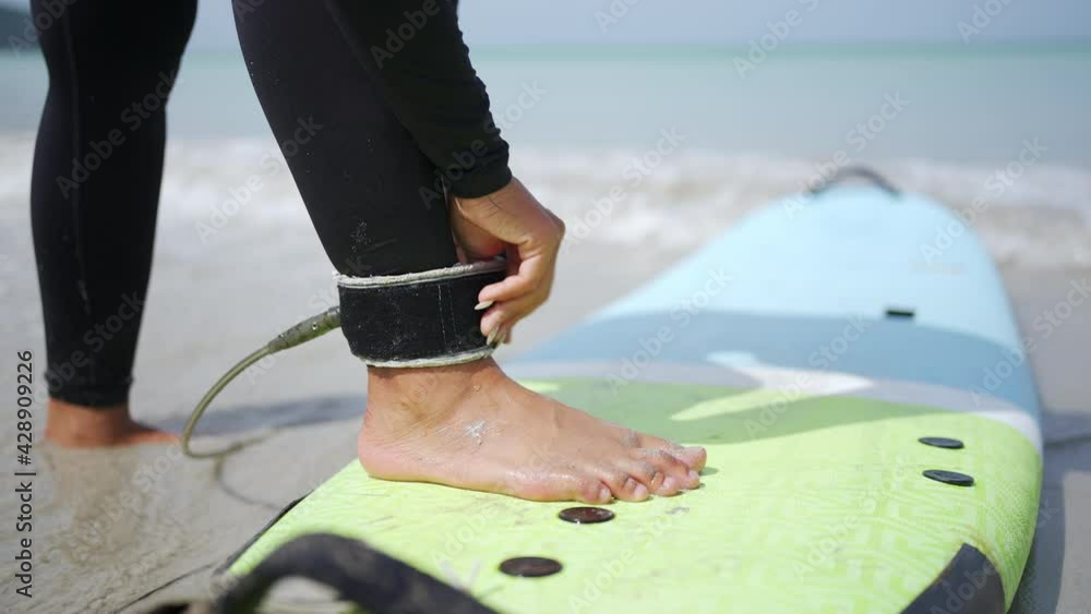 4K Confidence Asian woman in wetsuit wear surfboard safety leg rope ...