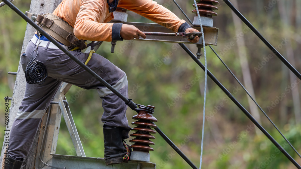 Rural electric poles are being repaired by electricians installing ...