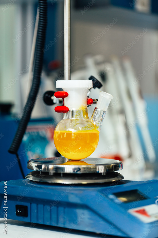 flask with laboratory glassware in the background of a chemical ...