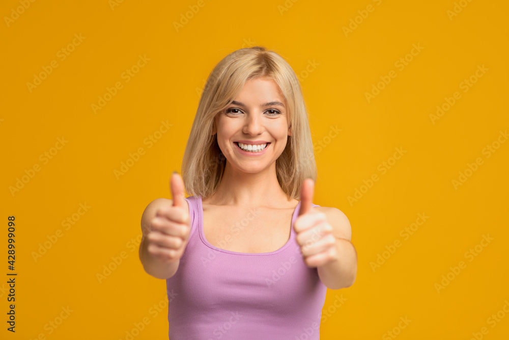 Everything is fine. Happy lady making thumb up gesture, recommending ...