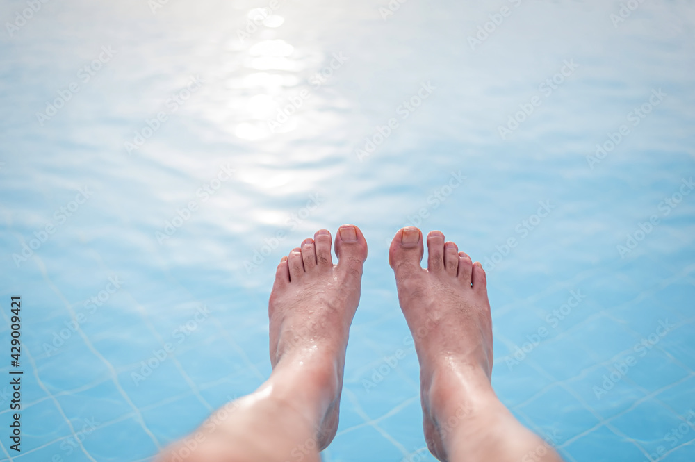 Overhead photo of feet on a background of water in swimming pool ...