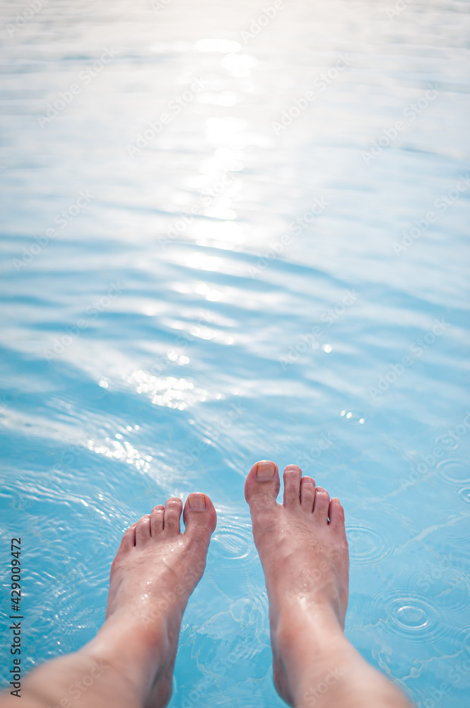 Overhead photo of feet on a background of water in swimming pool ...