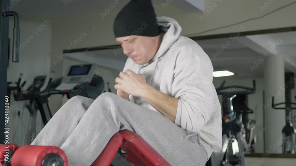Bodybuilder performs abs exercises on a roman chair. Athlete in a black ...
