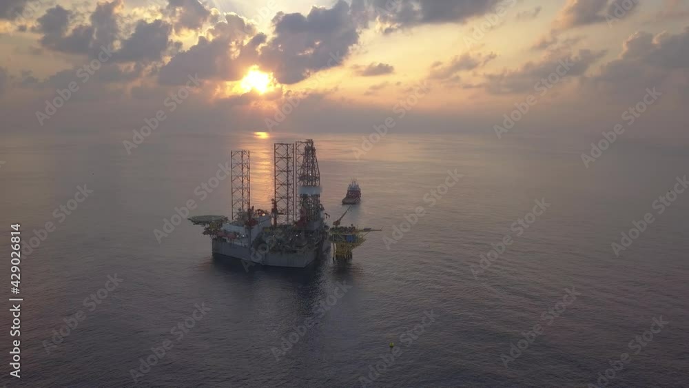 Aerial view of the jack up rig shot during sunset time. Fly around the ...