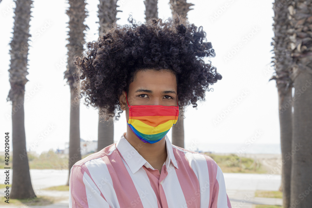 Portrait of a young African man wearing pride mask - LGBT during the ...
