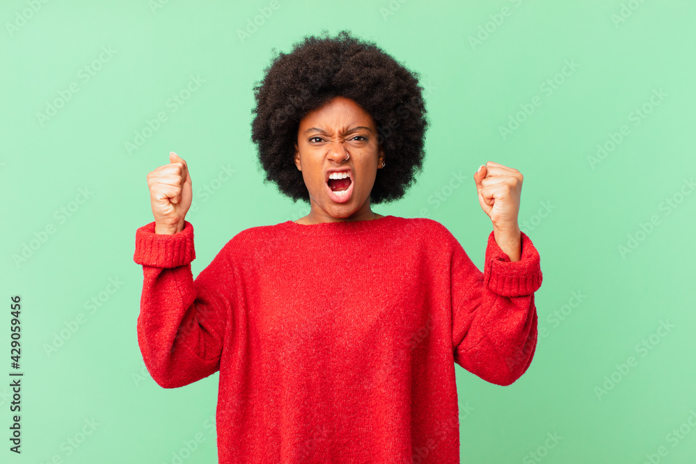 afro black woman shouting aggressively with an angry expression or with ...