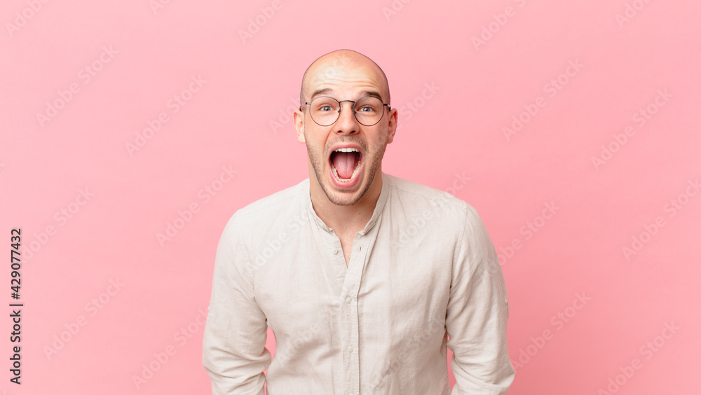 bald man shouting aggressively, looking very angry, frustrated ...