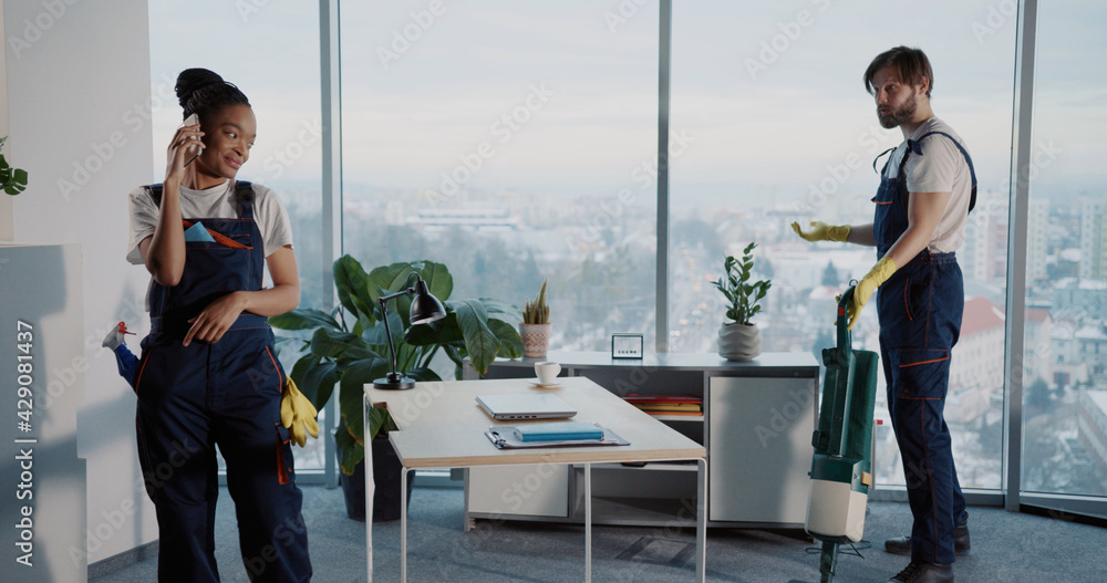 Lazy african young talkative woman dialing mobile phone while her tired ...