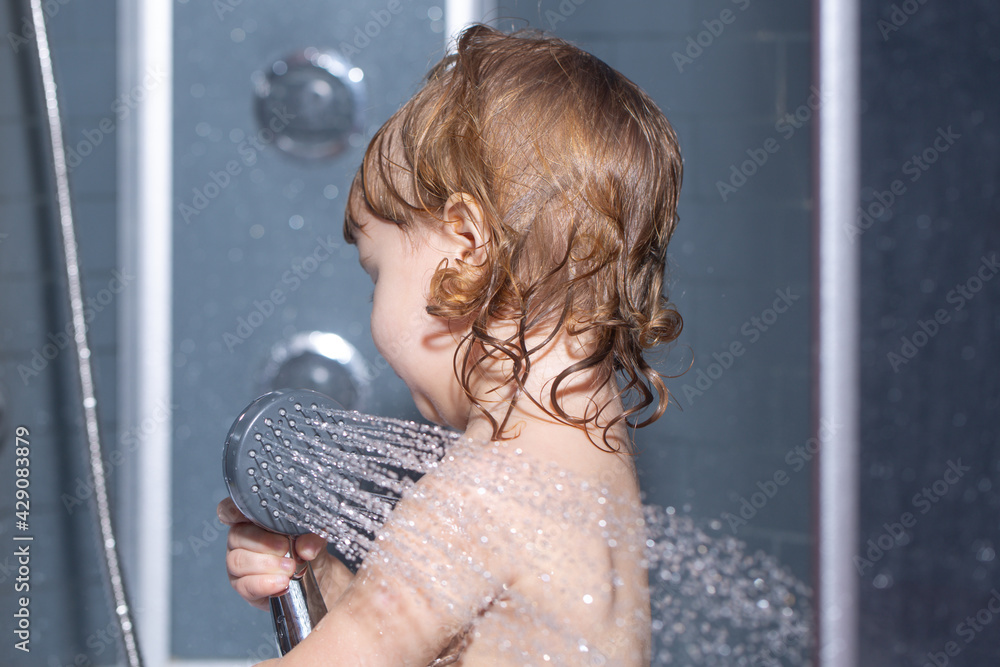 Child bathing in bathroom. Happy kid with soap foam on head. Stock ...