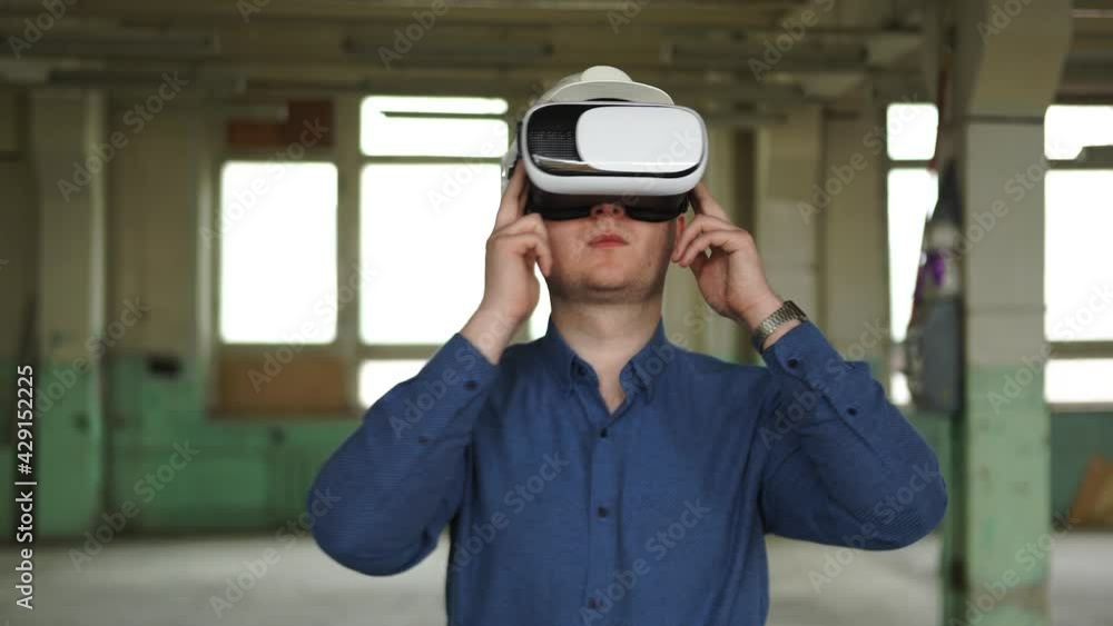Architect wearing virtual reality glasses protective helmet. Examines ...