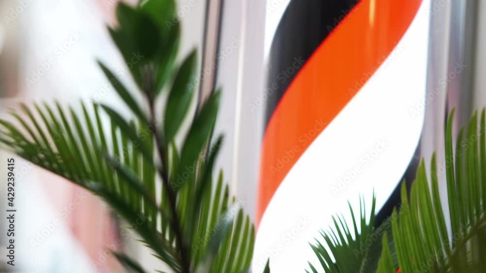 Traditional sign barber pole rotating on wall outside hairdresser shop ...