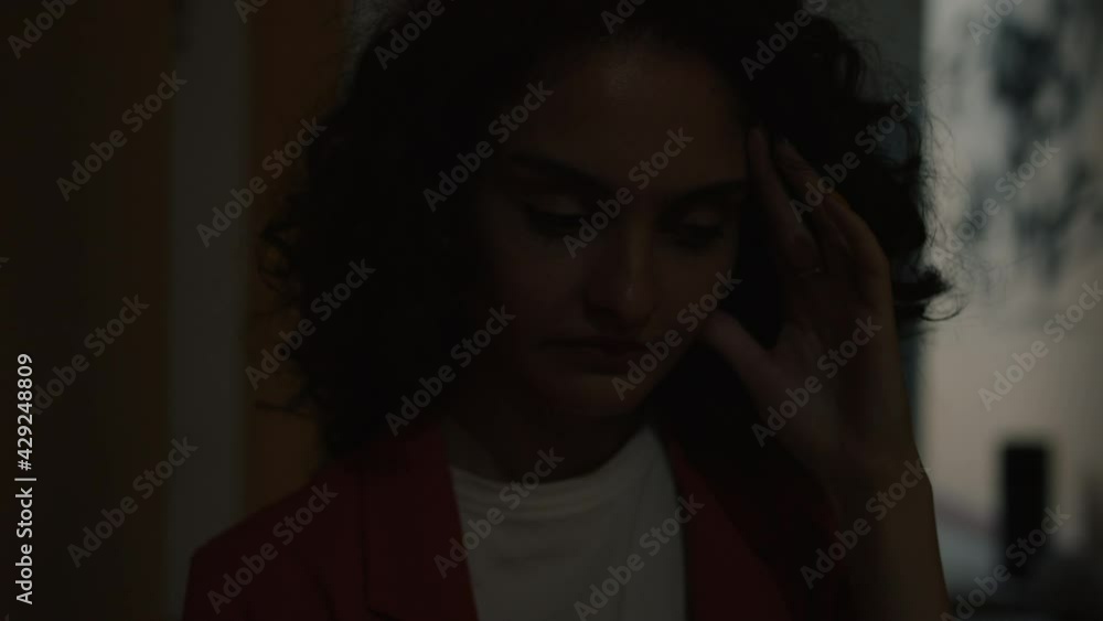 Portrait of scared young woman standing outdoors illuminated with ...