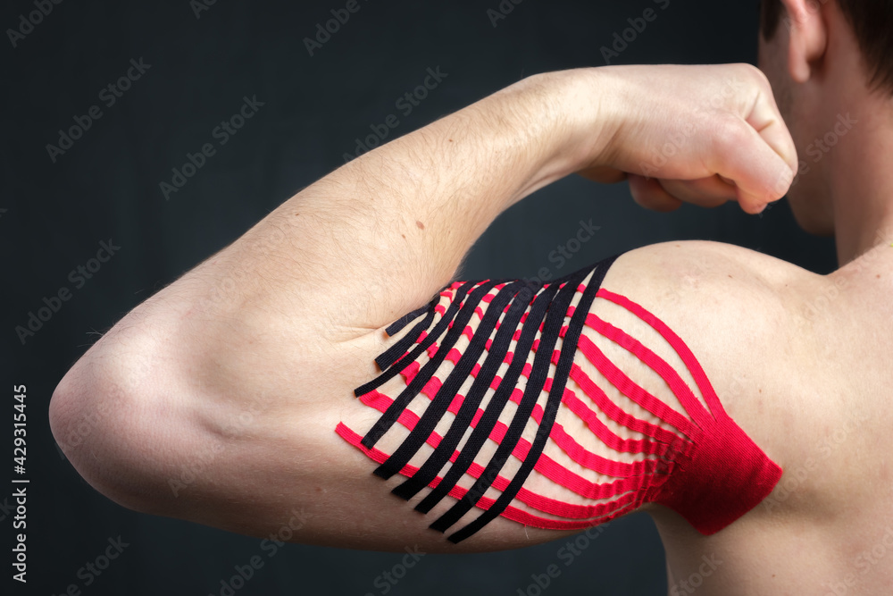 Young caucasian man showing bicep with kinesiology medical tape applied ...