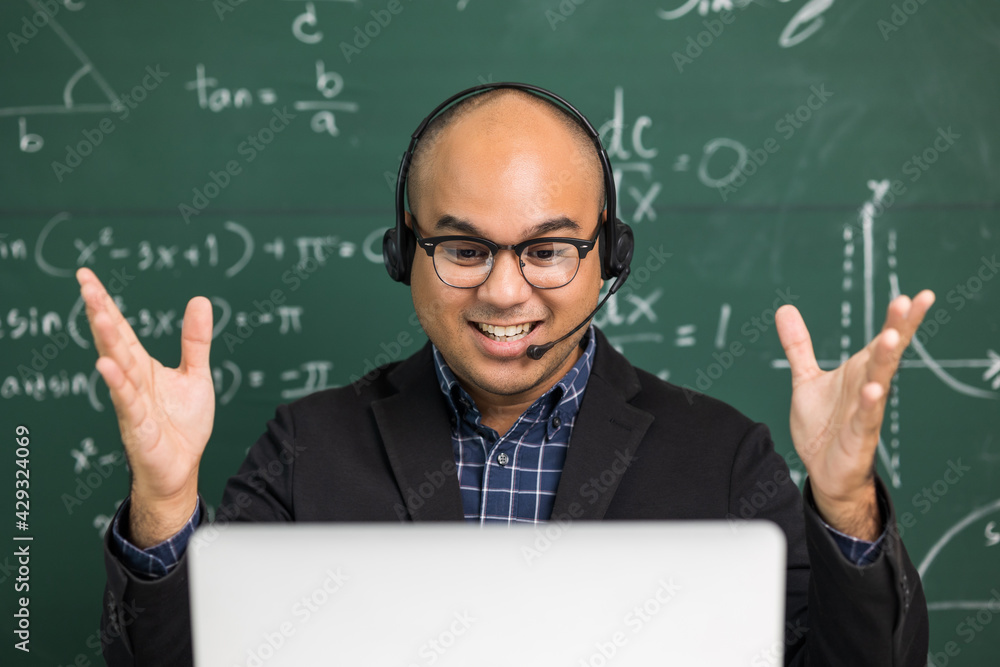 Indian young teacher man sitting wearing headset teaching online video ...