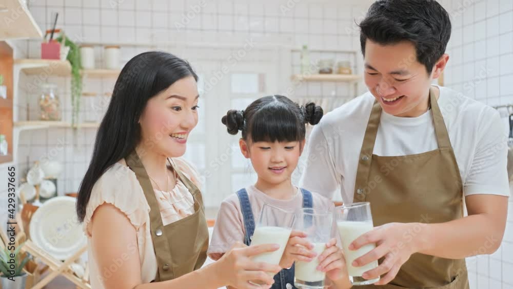 Asian happy family drinking milk together in the kitchen at home. Stock ...