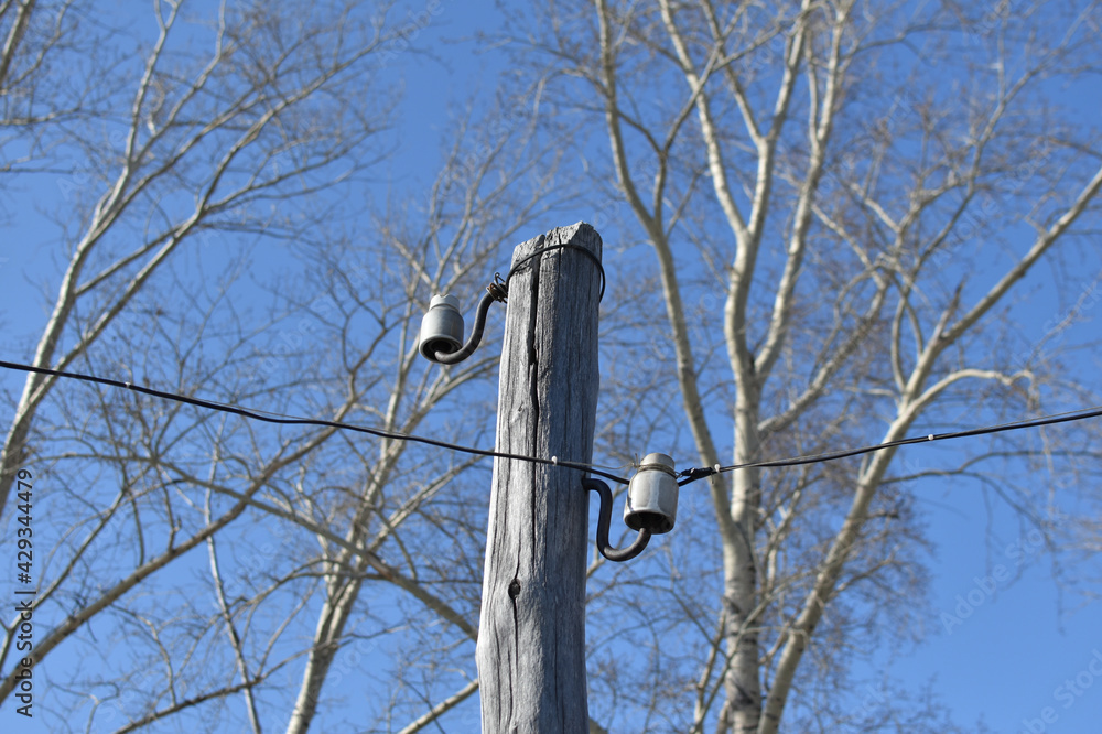 wooden support for power lines. Rural landscape. Homemade pole with ...
