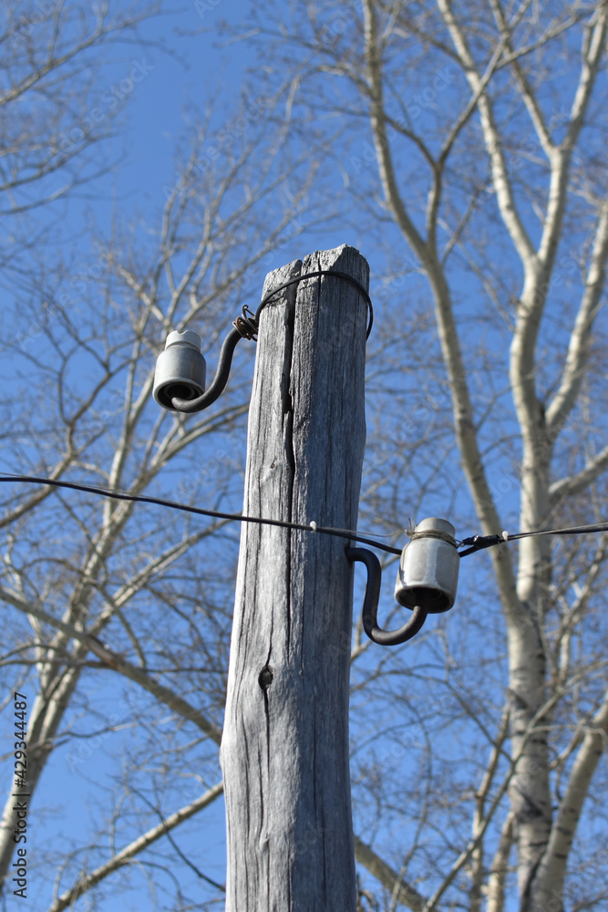 wooden support for power lines. Rural landscape. Homemade pole with ...