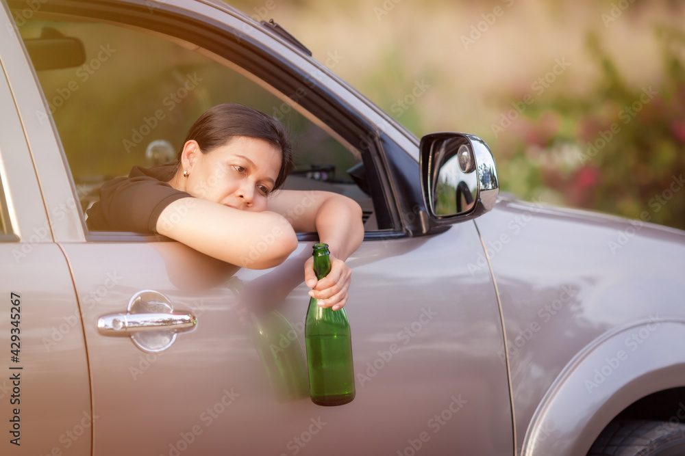 dangerous driving - young woman drinking beer and driving car, drinking ...