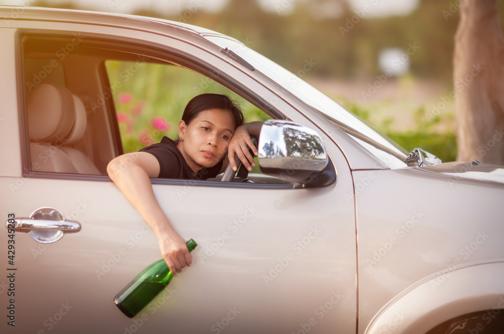 dangerous driving - young woman drinking beer and driving car, drinking ...