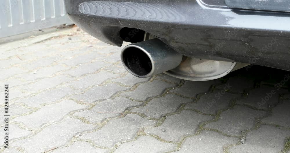 Generic gas car exhaust muffler tip putting out white fumes while ...