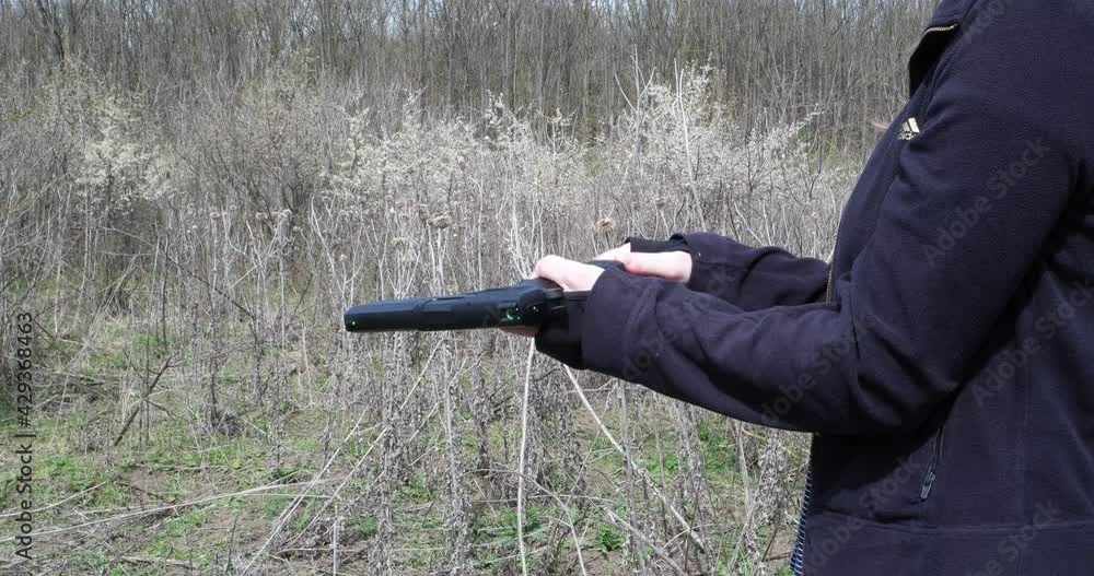 Woman practicing reloading the presumed air tank cartridge on a bb gun ...