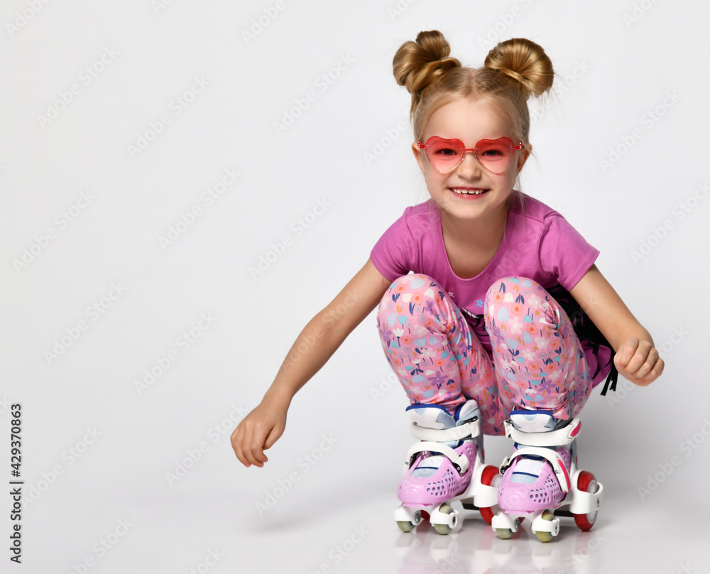 Full body portrait of positive funky little girl wearing roller skates ...