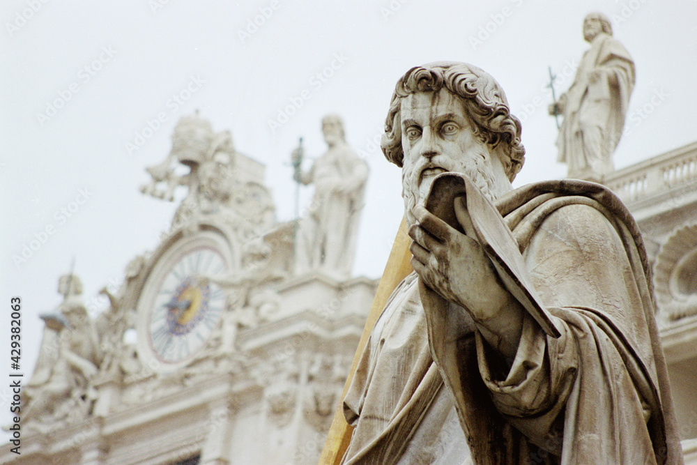The statue of St. Paul in front of the facade of St. Peter's basilica ...