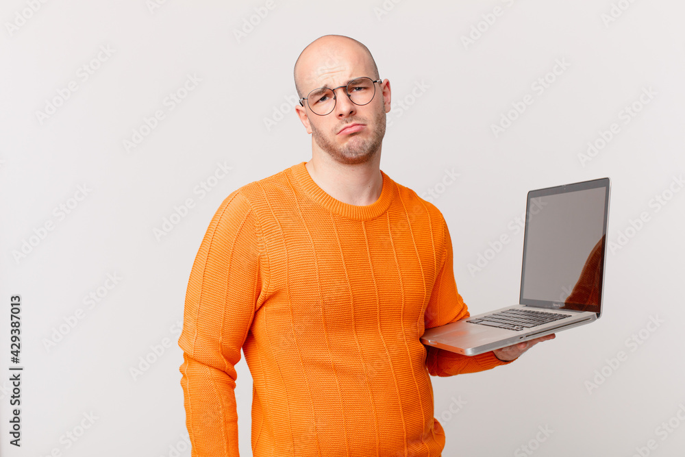 bald man with computer feeling sad and whiney with an unhappy look ...