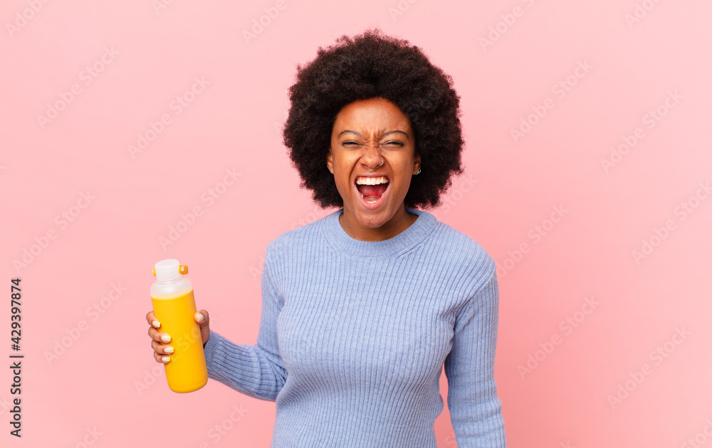 afro woman shouting aggressively, looking very angry, frustrated ...