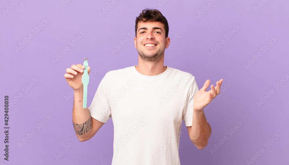 man with a watch feeling happy, surprised and cheerful, smiling with ...